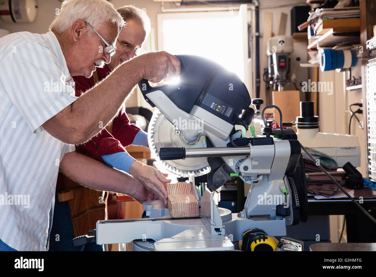 Senior men sawing on circular saw in carpentry workshop Stock Photo - Alamy