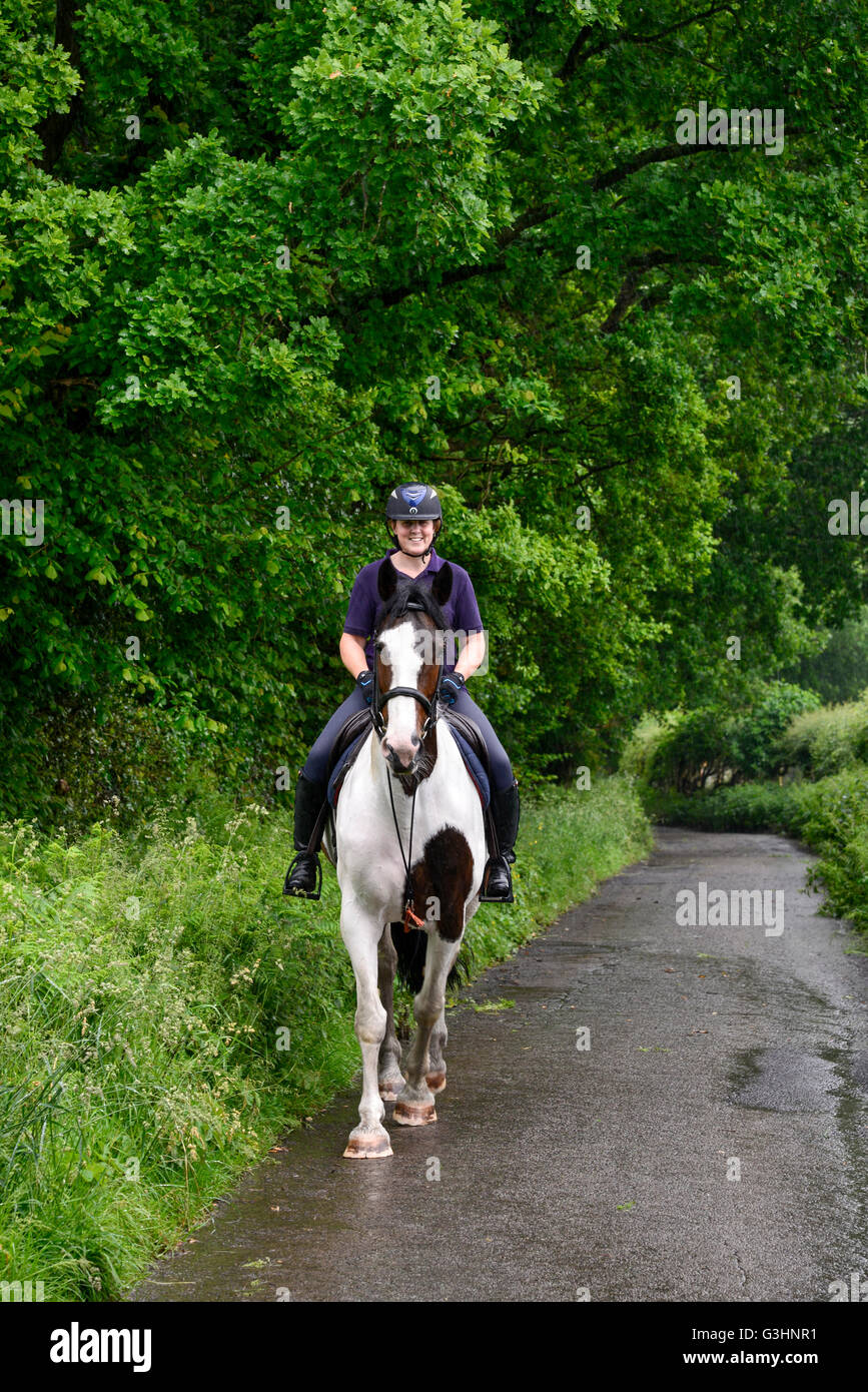 Horse rider on a country lane on a rainy summer day. Smile on the face ...