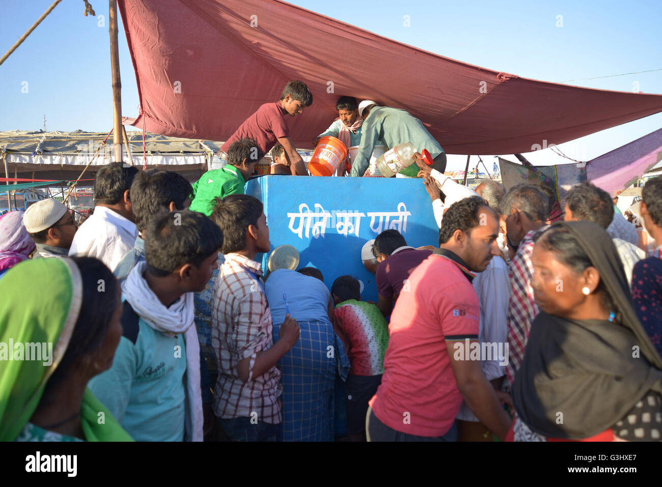 Indian Sufi Muslim devotees collect drinking water from a tanker at a ...