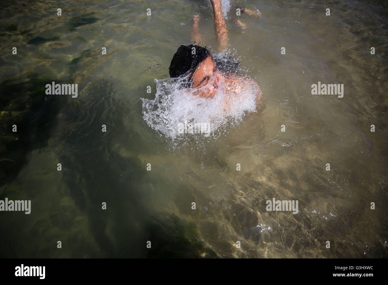A Palestinian boy swims in the sea near Gaza seaport in western of Gaza ...