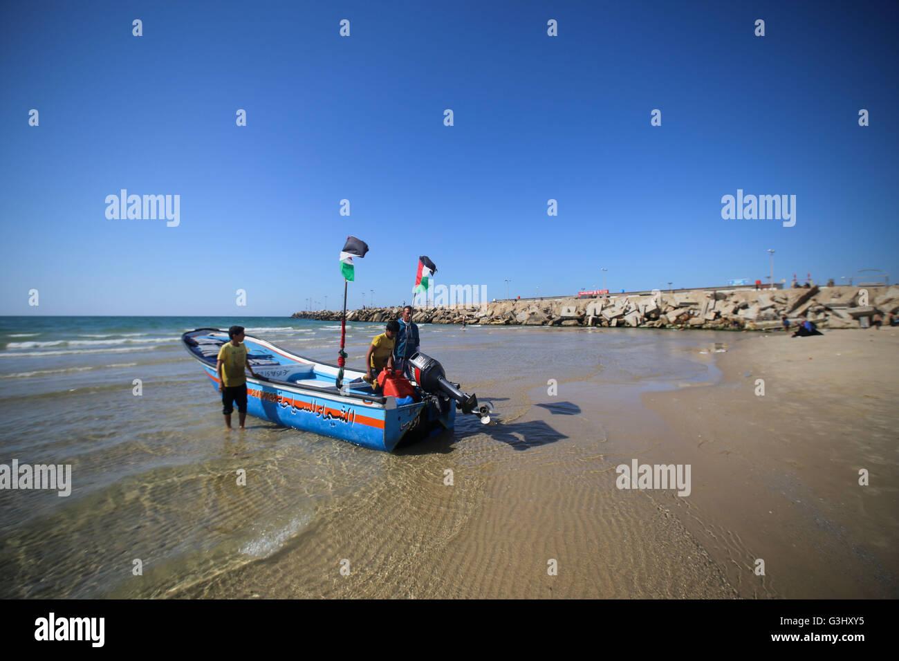 Palestinian youths stands on the beach with their ship near Gaza ...