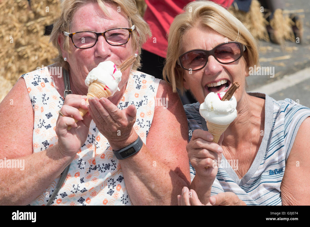 Two ladies enjoy their ice-cream during Gala Parade Stock Photo - Alamy