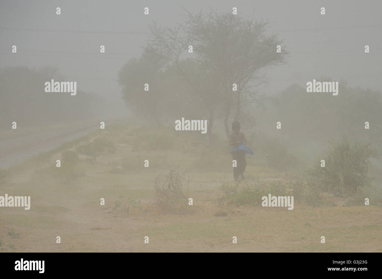 People walking through a heavy dust storm. A strong dust storm lashed ...