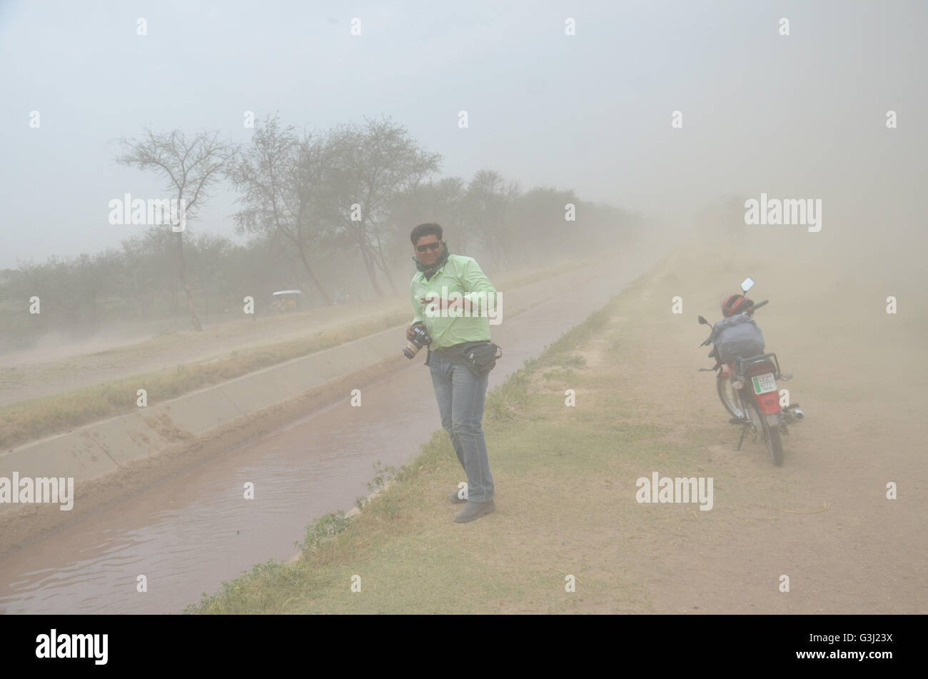 People walking through a heavy dust storm. A strong dust storm lashed ...