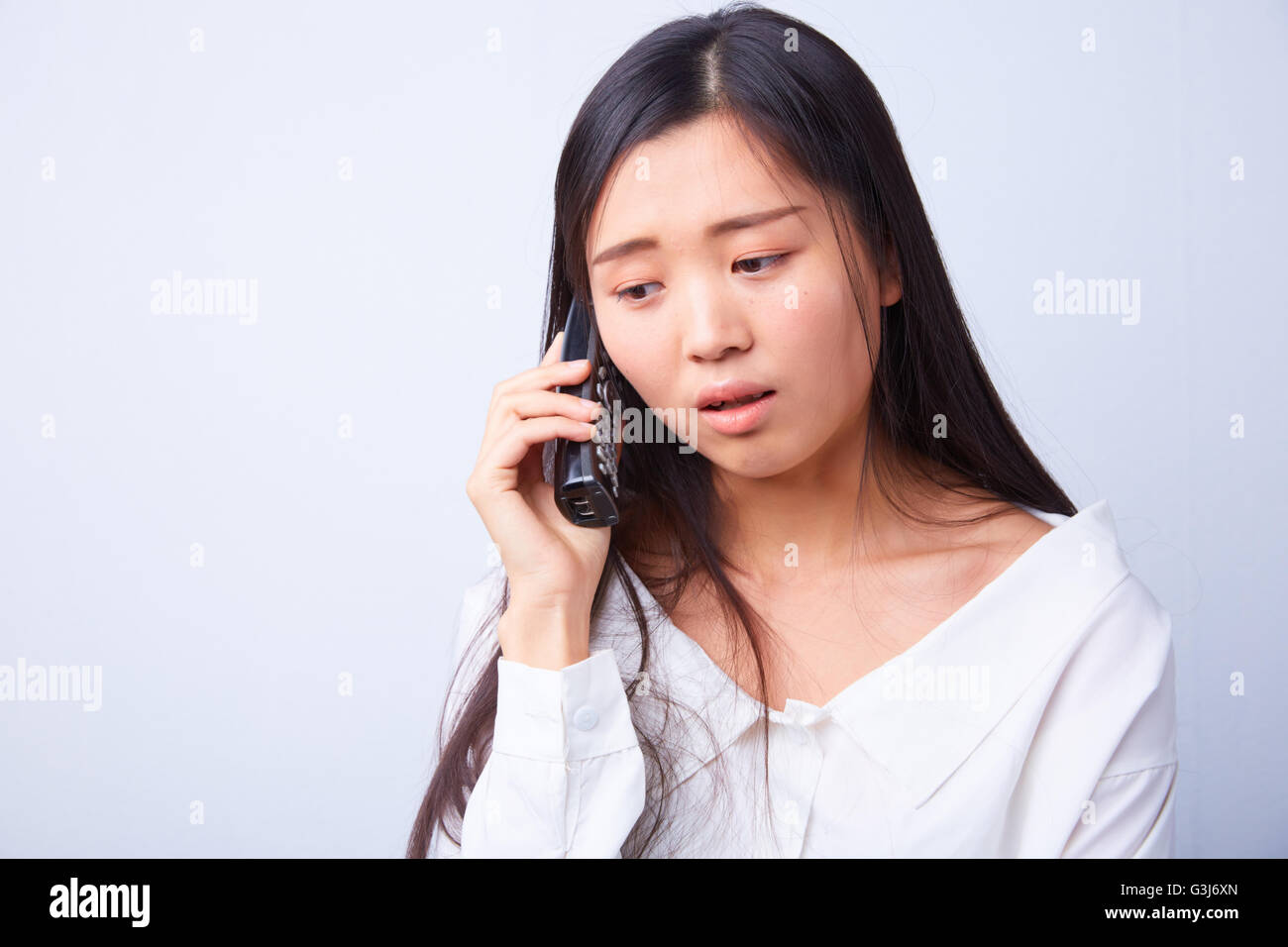 sad Chinese woman talking on a phone Stock Photo - Alamy