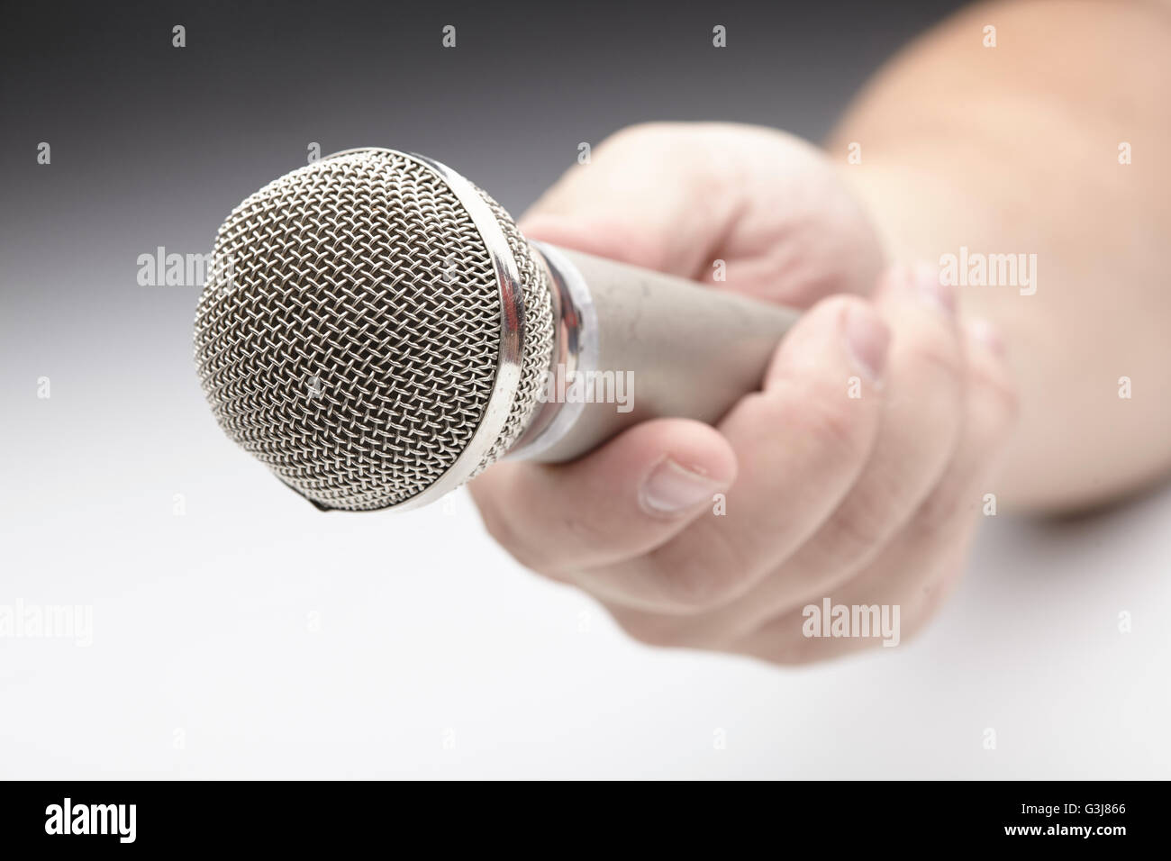 Microphone in a man's hand Stock Photo - Alamy