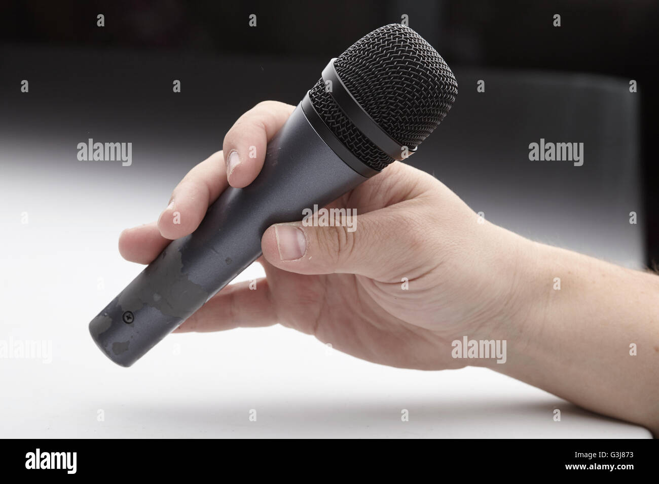 Microphone in a man's hand Stock Photo - Alamy