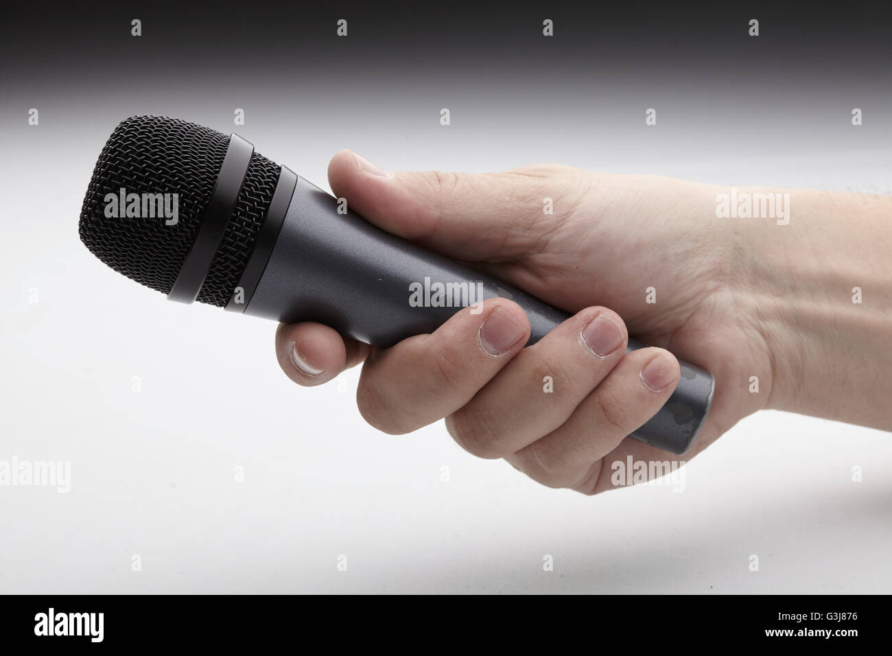 Microphone in a man's hand Stock Photo - Alamy