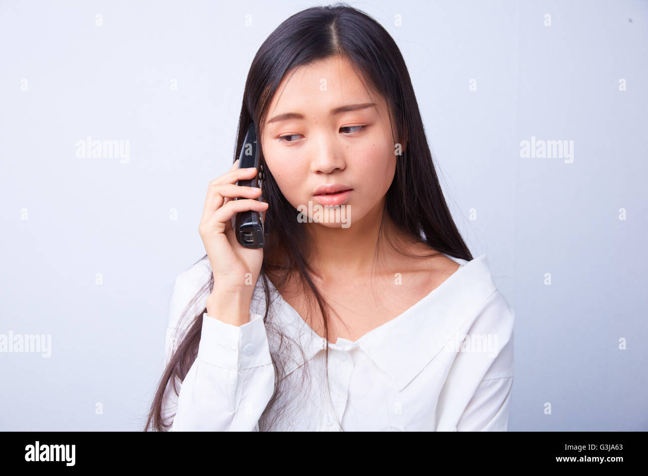 sad Chinese woman talking on a phone Stock Photo - Alamy