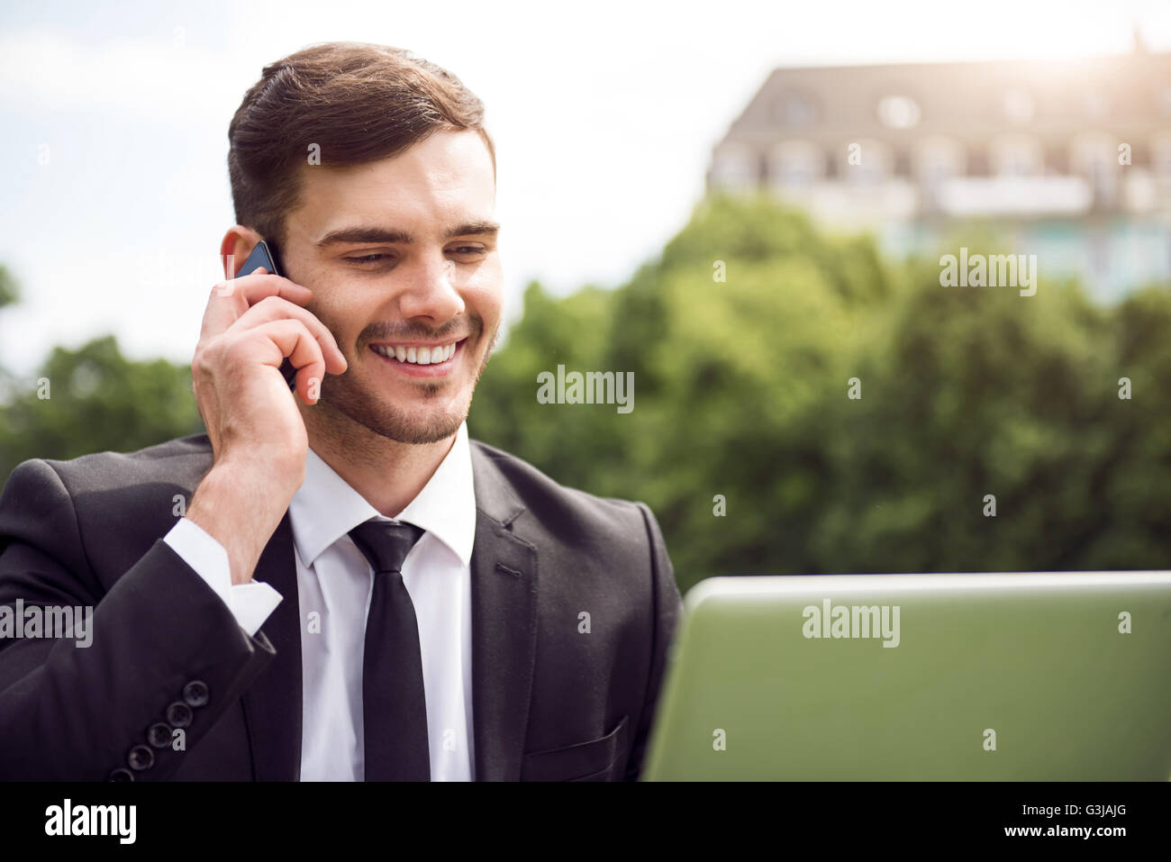 Handsome delighted man sitting on the grass Stock Photo - Alamy