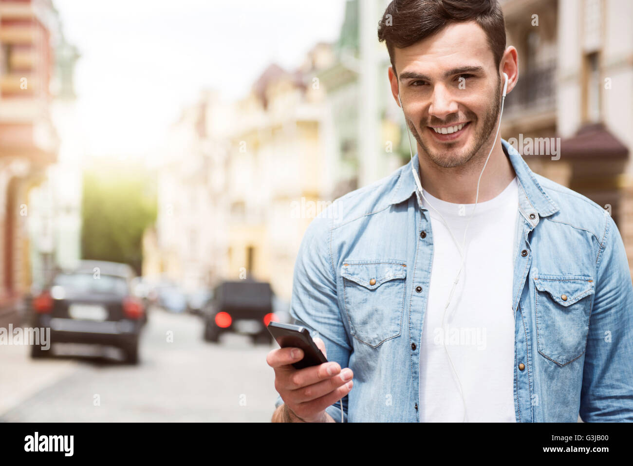Positive man holding cell phone Stock Photo - Alamy