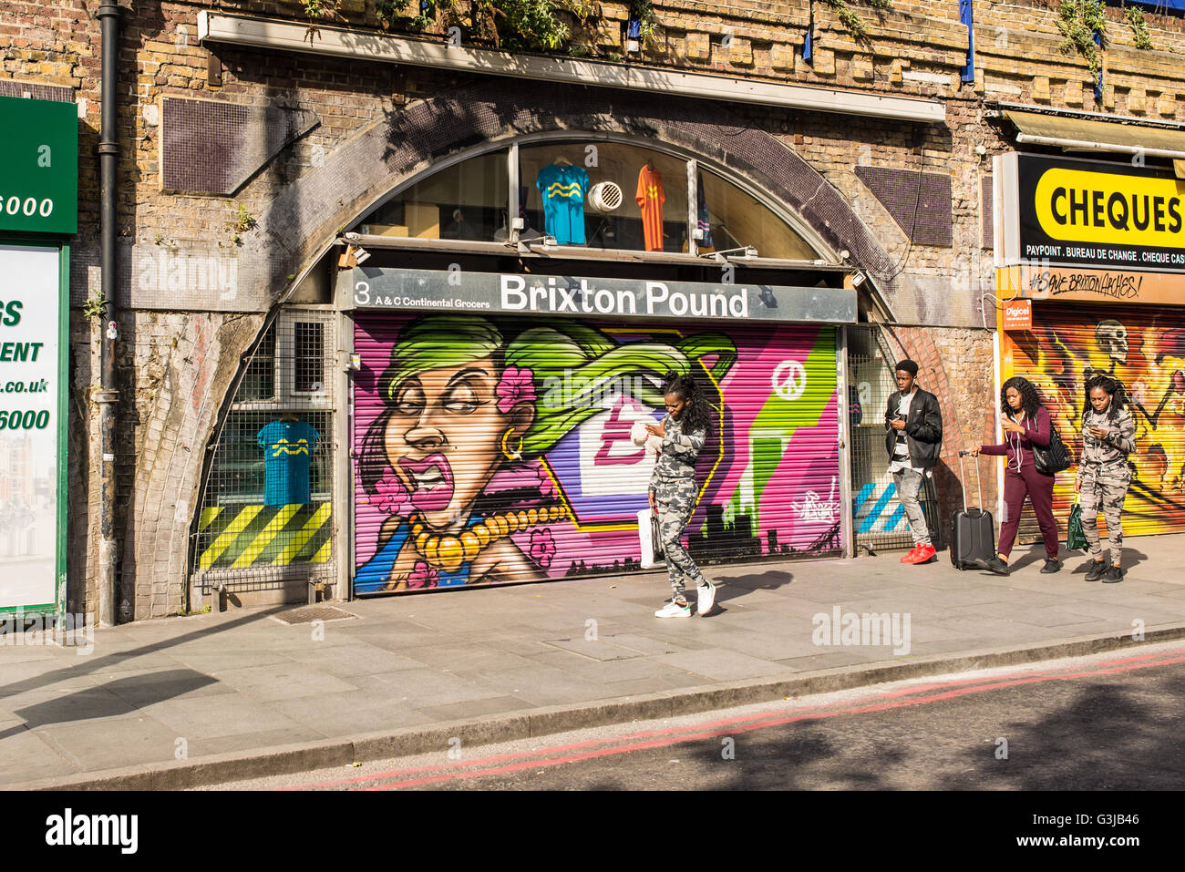 People walking in front of the Brixton Pound Shop. Brixton pound is ...