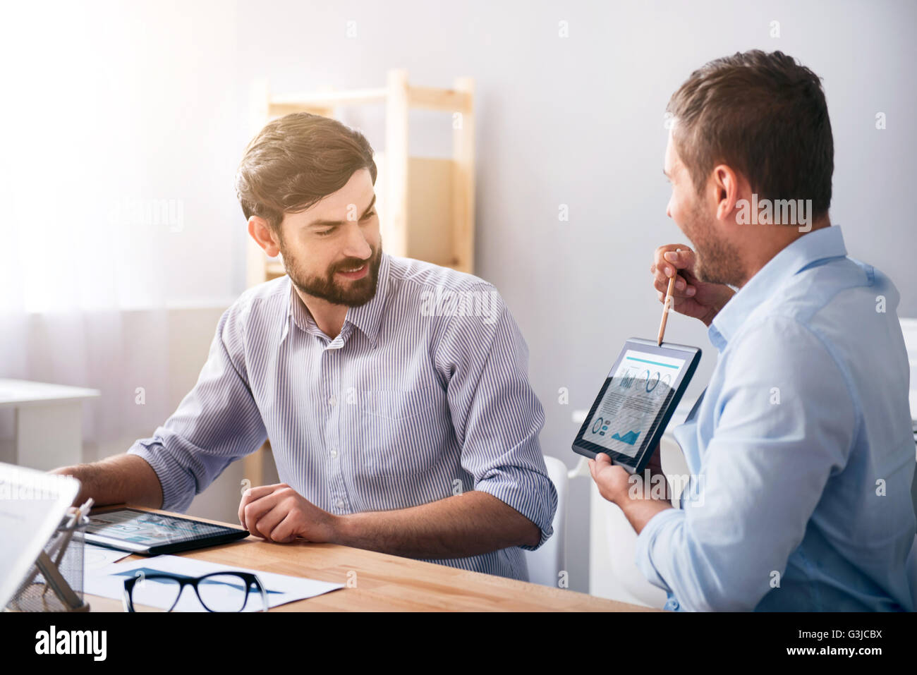 Positive colleagues sitting at the table Stock Photo - Alamy