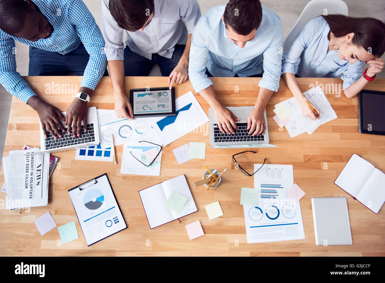Positive colleagues sitting at the table Stock Photo - Alamy