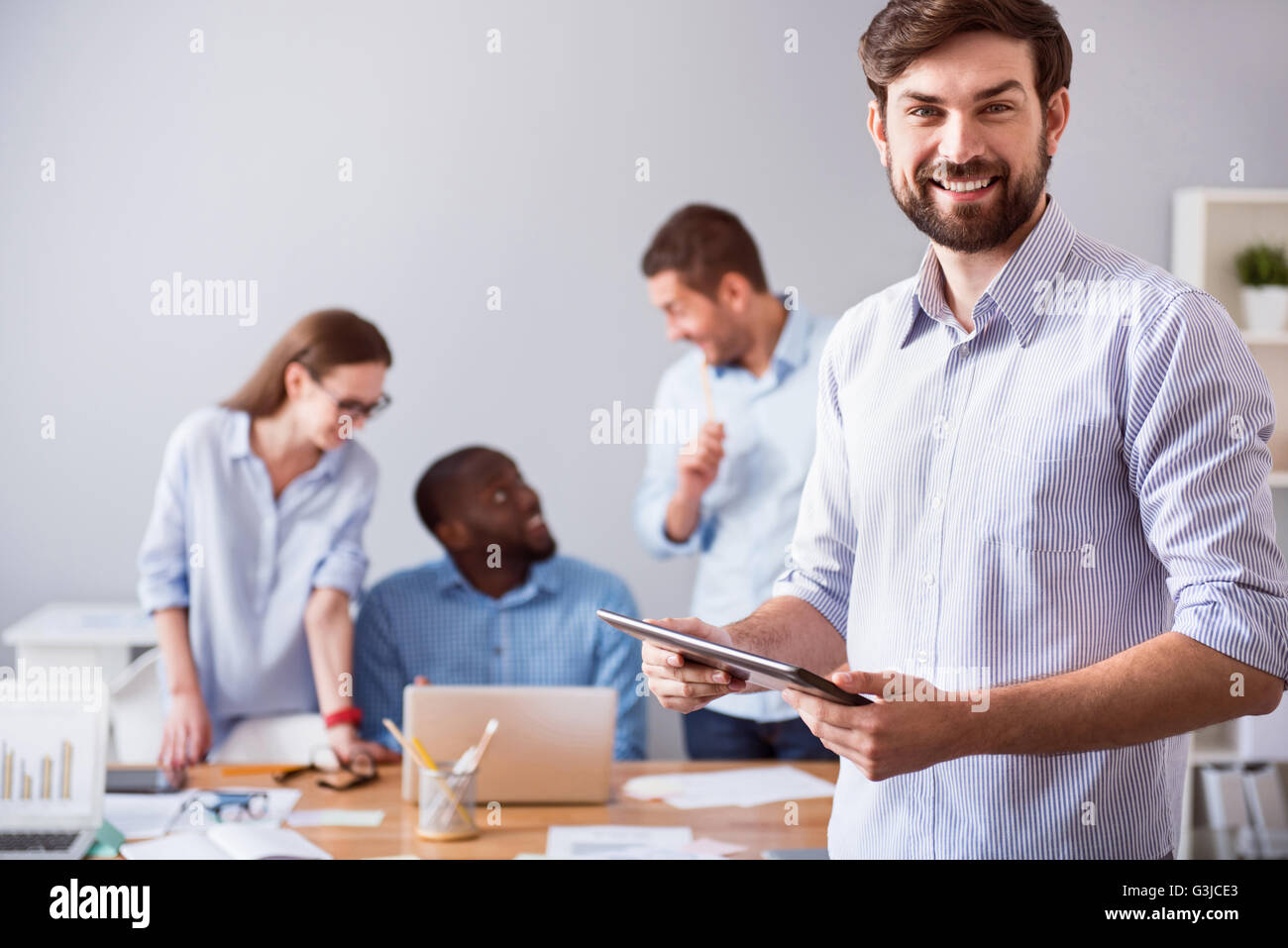 Positive smiling man standing in the office Stock Photo - Alamy