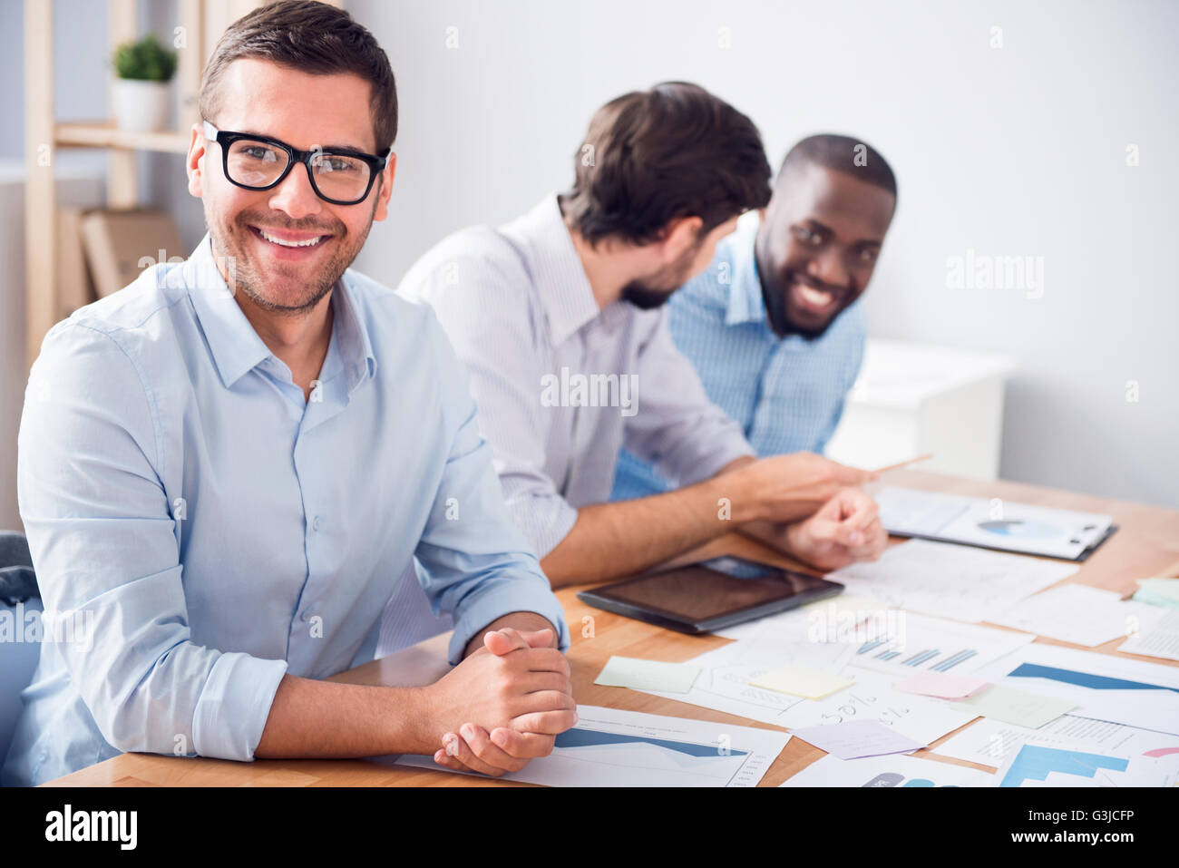 Positive man sitting at the table Stock Photo - Alamy