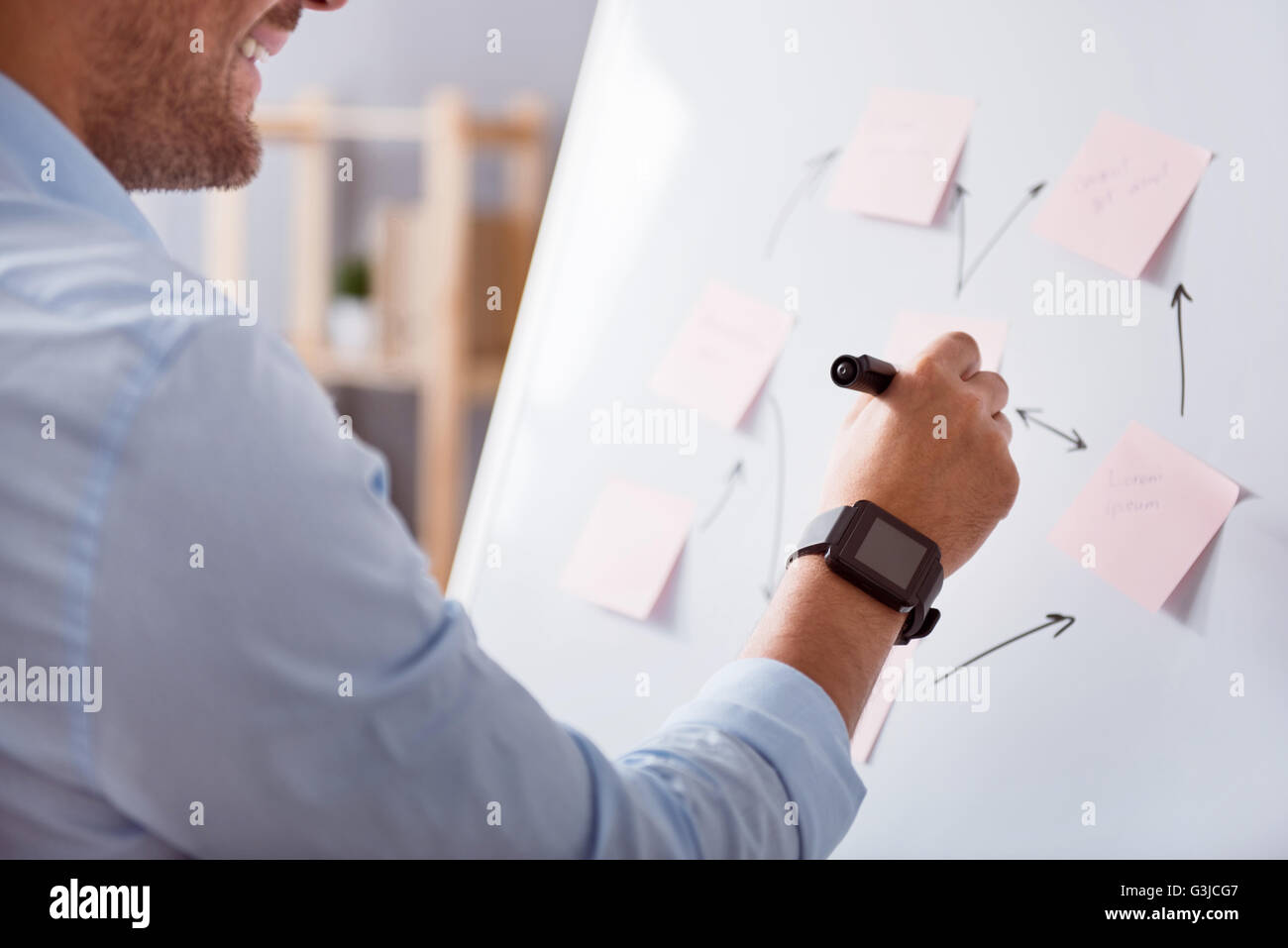Positive smiling man making notes on the board Stock Photo - Alamy