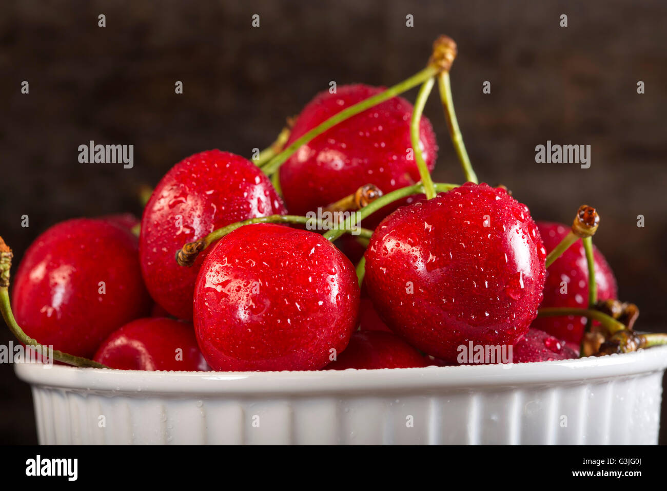Fresh red cherries in white bowl over rustic wooden background Stock ...