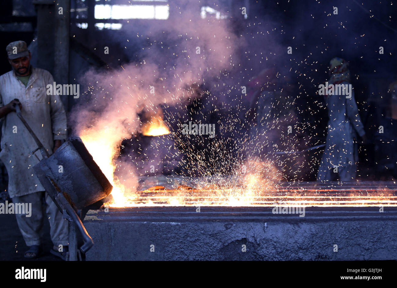 Pakistani blacksmiths work at an iron molding factory in an industrial ...