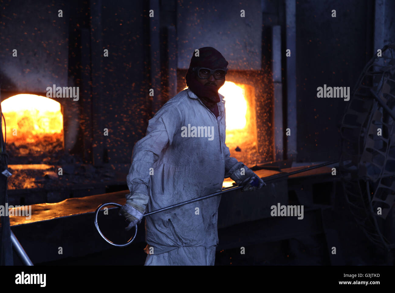 Pakistani blacksmiths work at an iron molding factory in an industrial ...