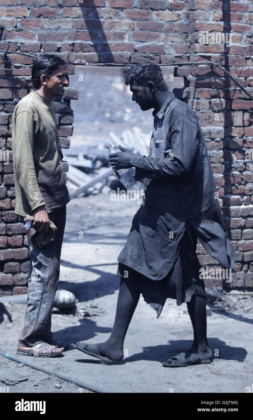 Pakistani blacksmiths work at an iron molding factory in an industrial ...