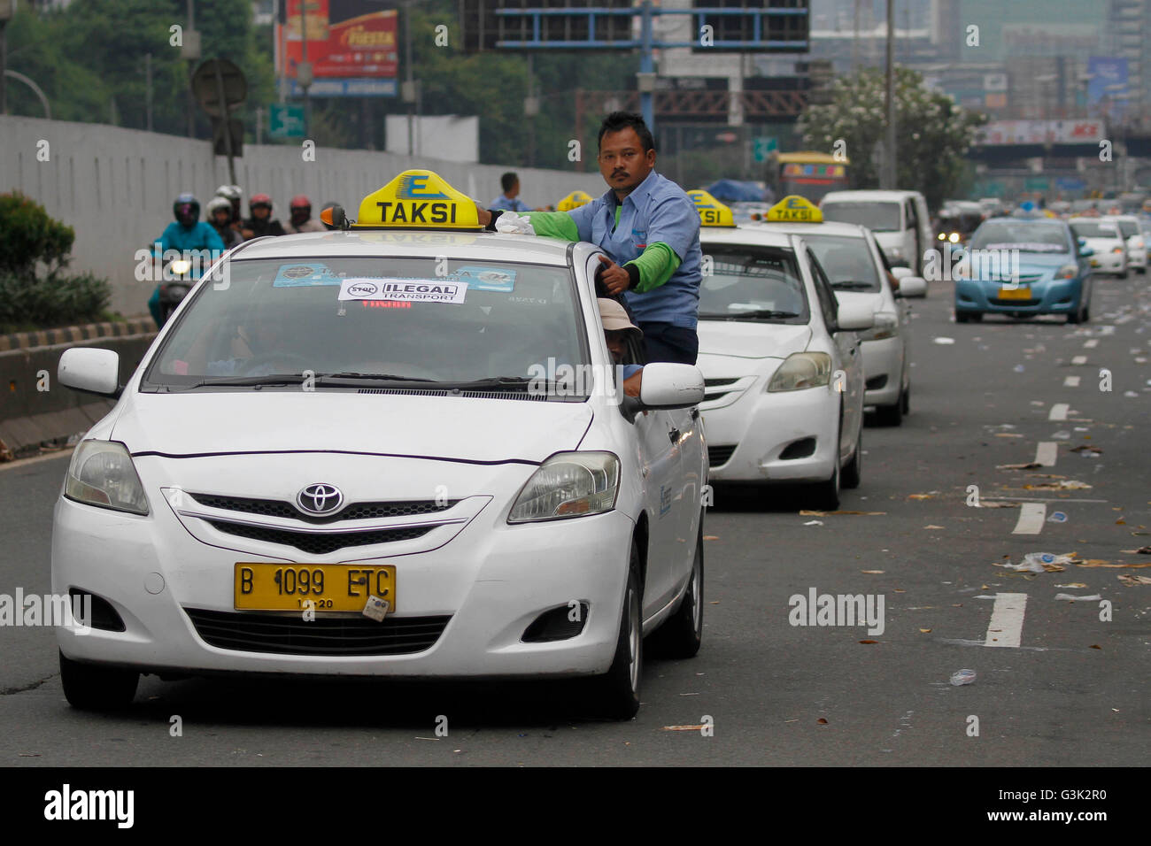 Jakarta, Indonesia. 22nd Mar, 2016. A taxi driver stands on his car ...