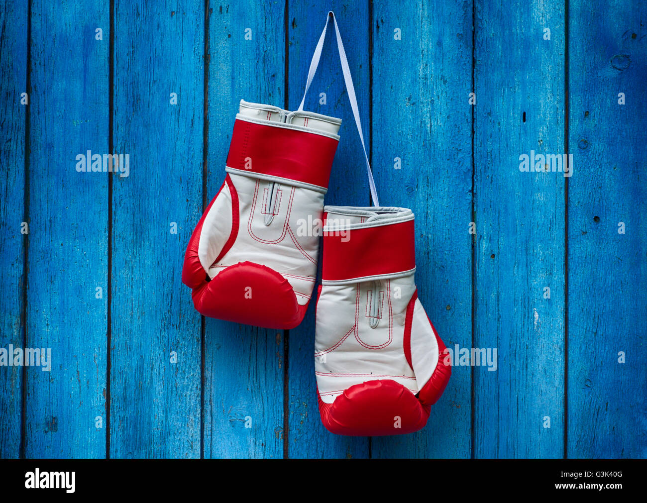 pair of red boxing gloves hanging on the old blue wooden wall Stock ...