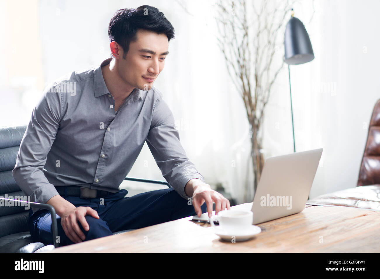 Young man working with laptop in office Stock Photo - Alamy