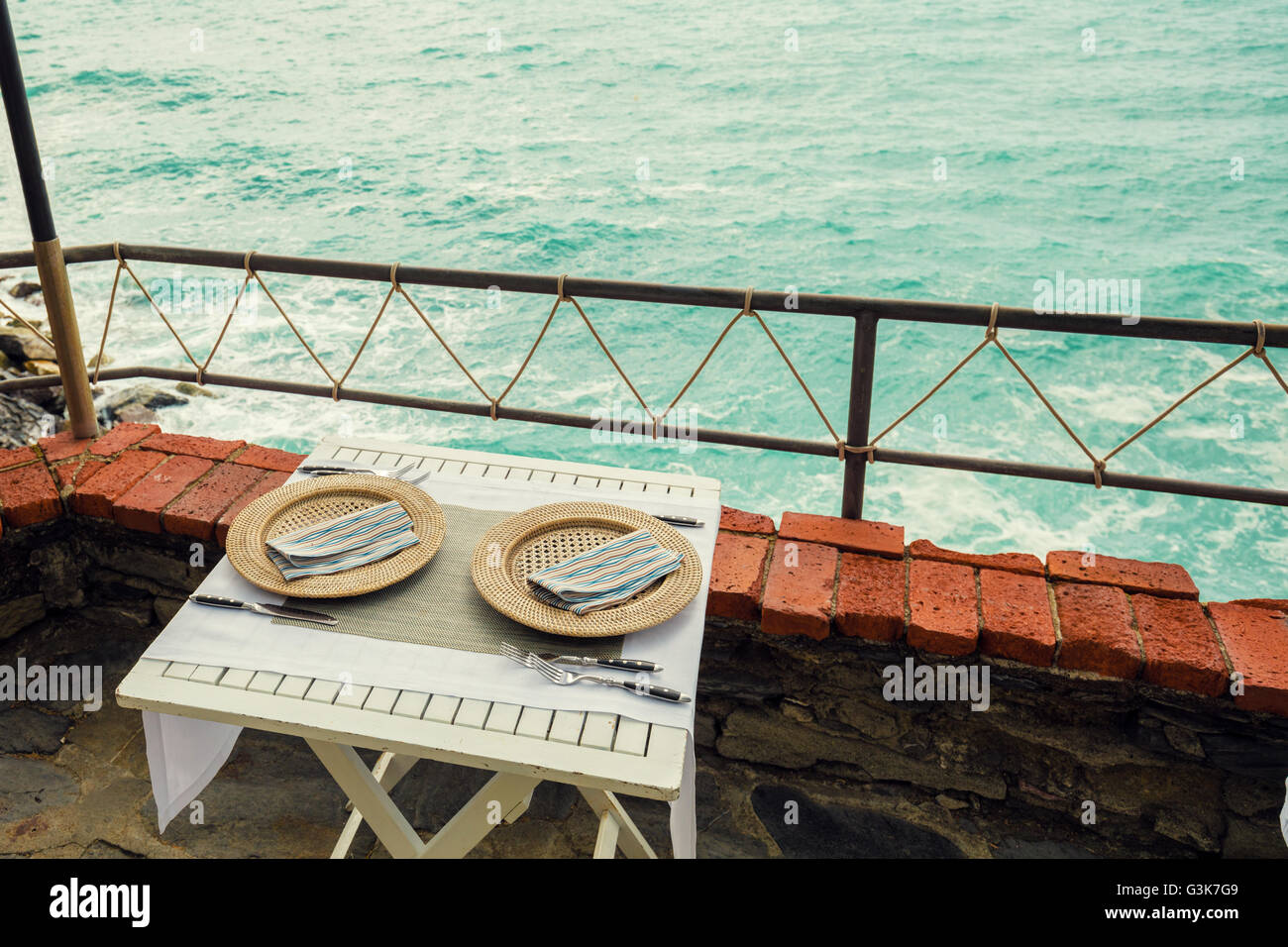 Served table for two with two plates for dinner at the beach on terrace ...