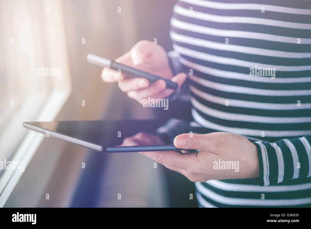 Smartphone and tablet data synchronization, woman syncing files and documents on personal ...