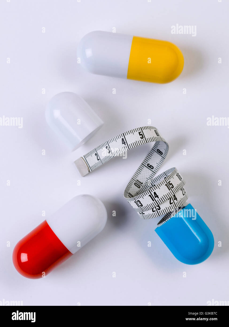 Slimming capsules, with a tape measure wrapped around one Stock Photo ...