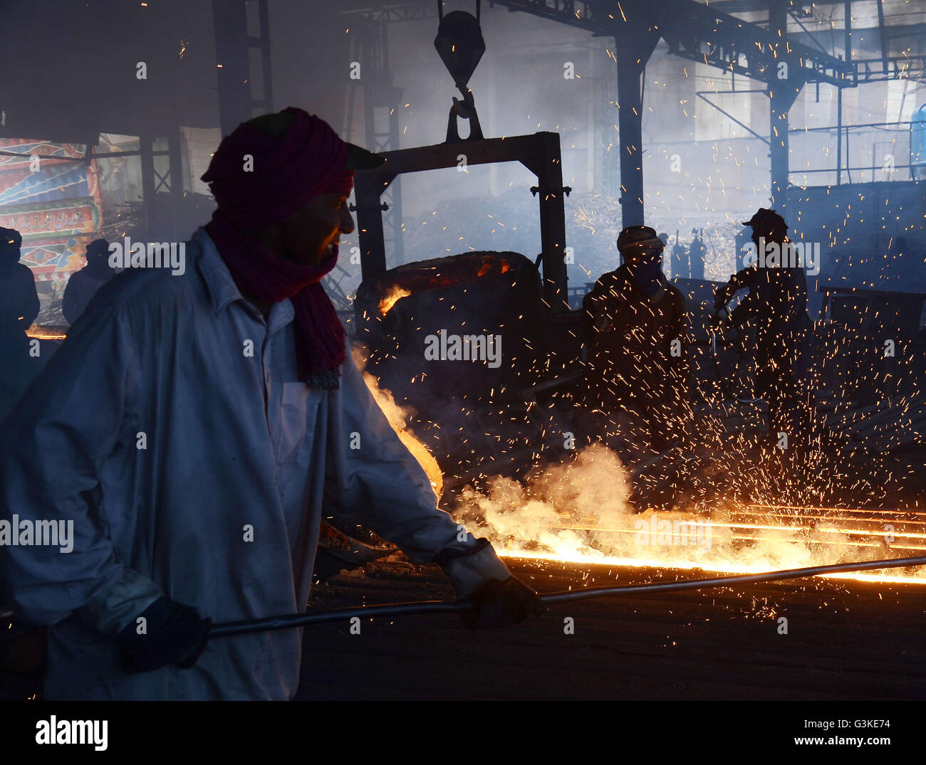 Pakistani blacksmiths work at an iron molding factory in an industrial ...