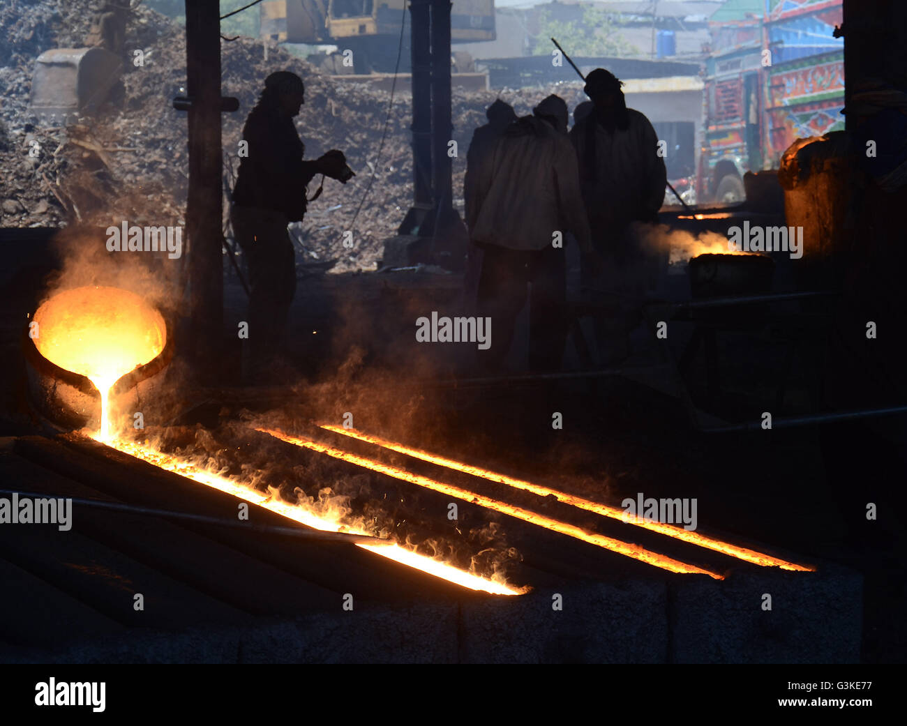 Pakistani blacksmiths work at an iron molding factory in an industrial ...