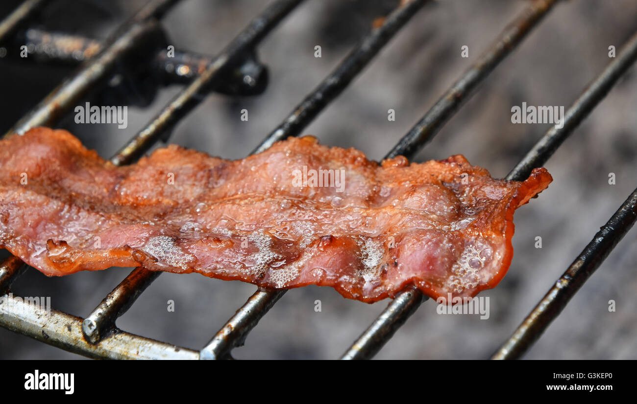 One crispy smoked grilled barbecue bacon slice, cooked on bbq smoke ...