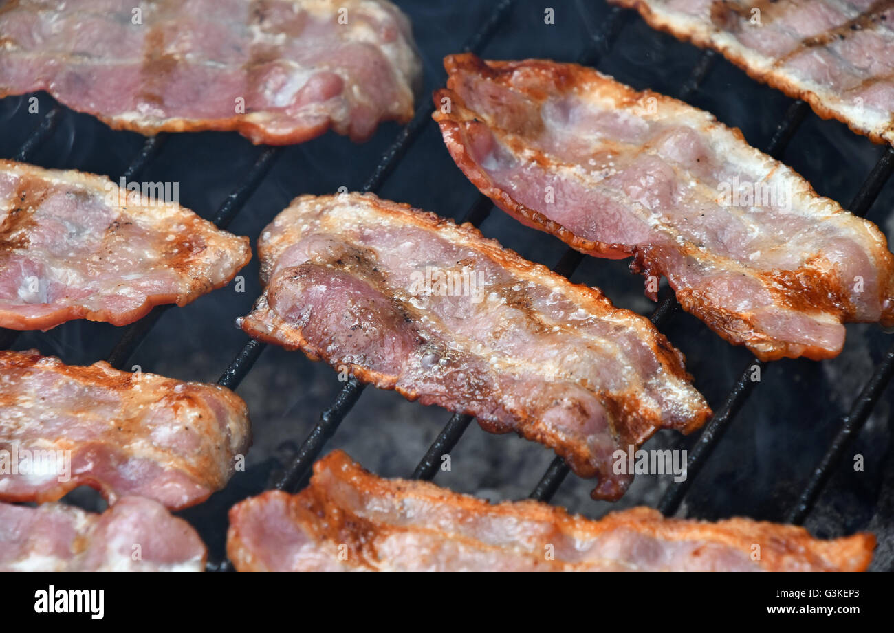 Crispy smoked grilled barbecue bacon slices, cooked on bbq smoke grill ...