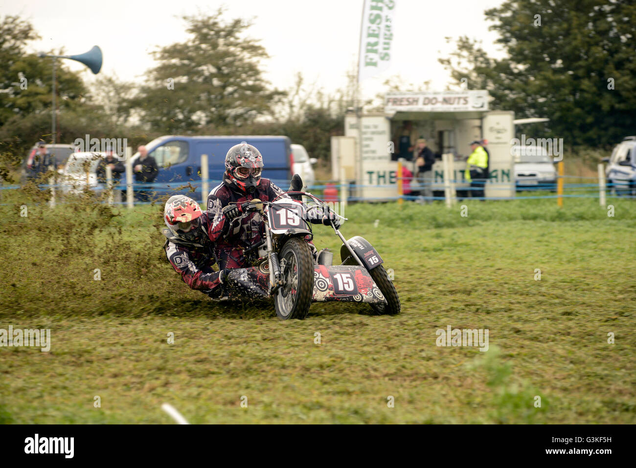 Motorcycle sidecar team negotiating a bend at a grass track racing ...