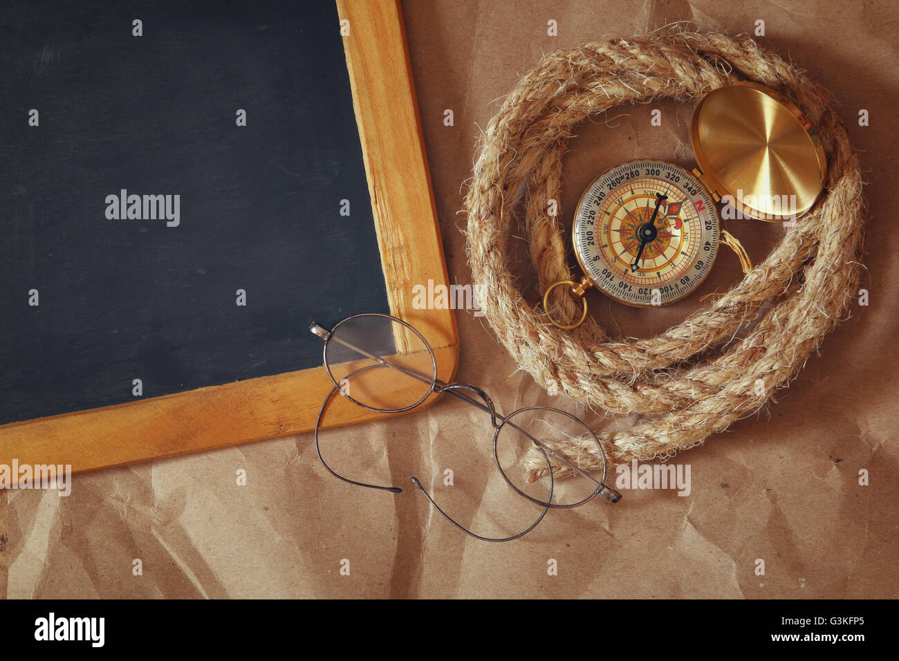 top view of compass, rope, old glasses and blank blackboard. explorer ...