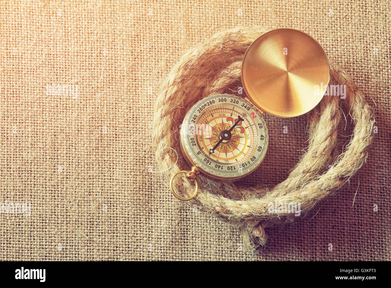 top view of compass on burlap canvas fabric background. explorer and ...
