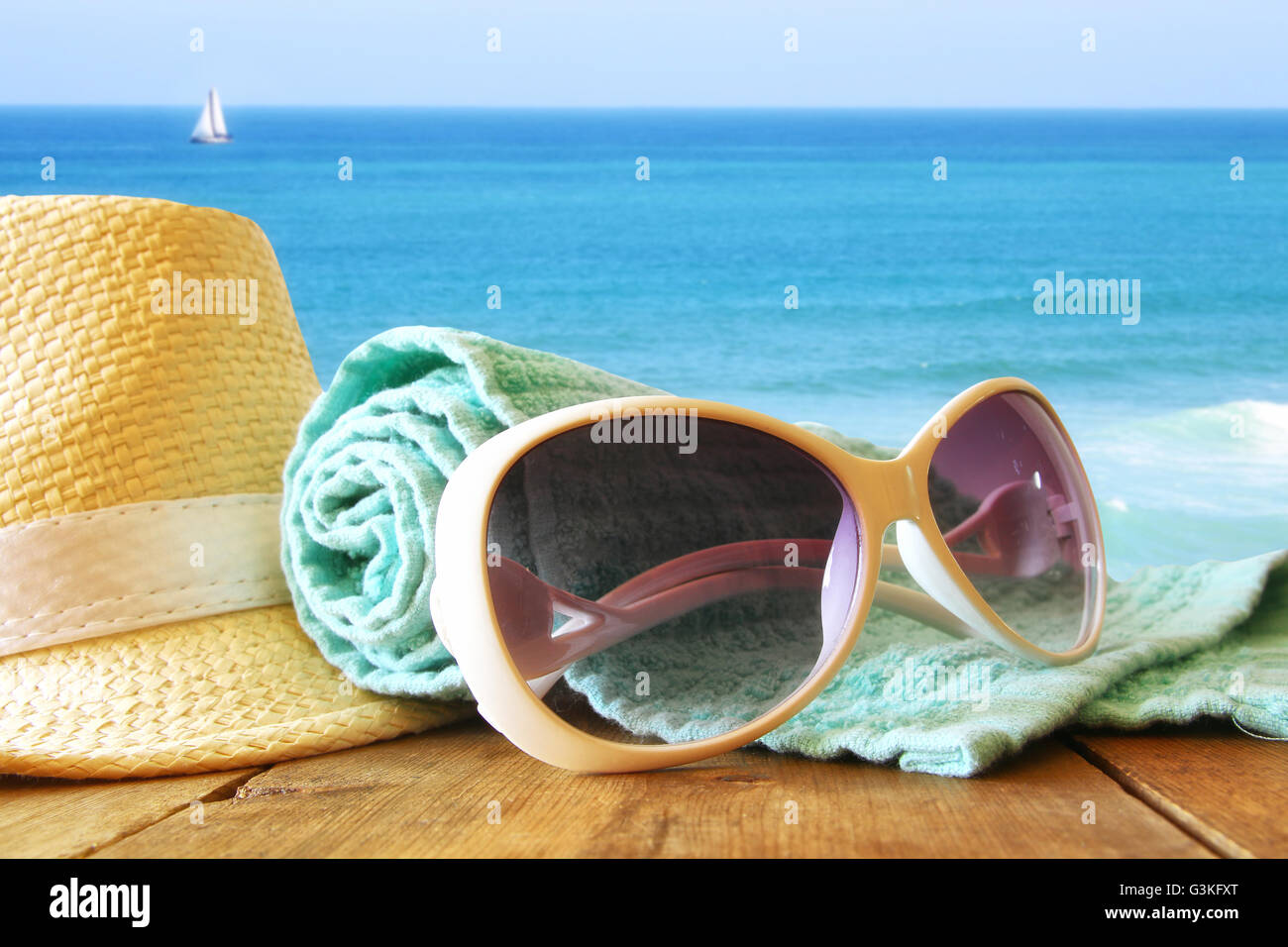 fedora hat and sunglasses over wooden table and sea landscape ...