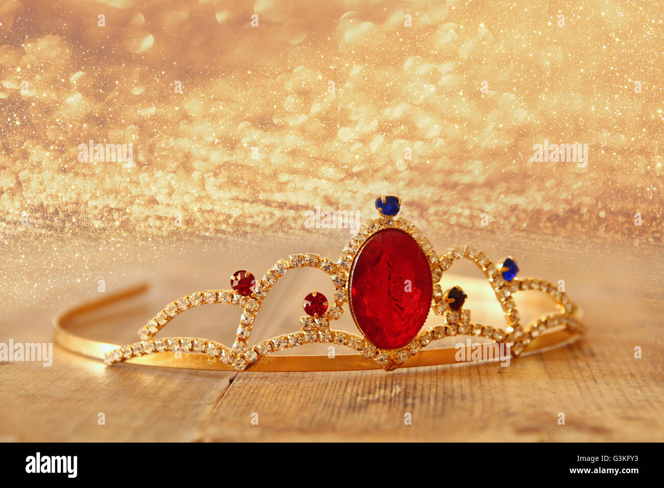 image of gold princes crown on wooden table and glitter background ...