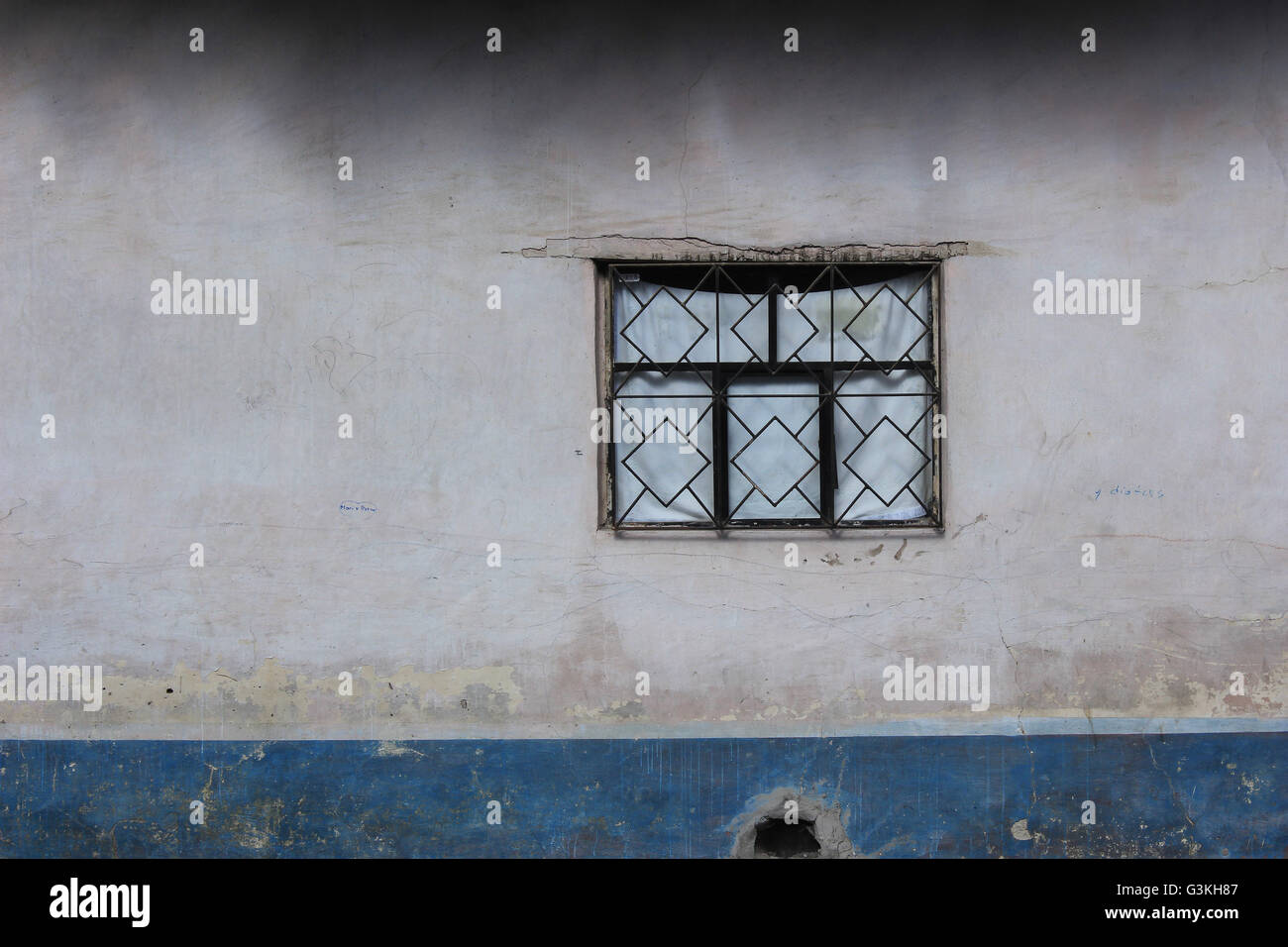 A barred window in the wall of a building in Cotacachi, Ecuador Stock ...