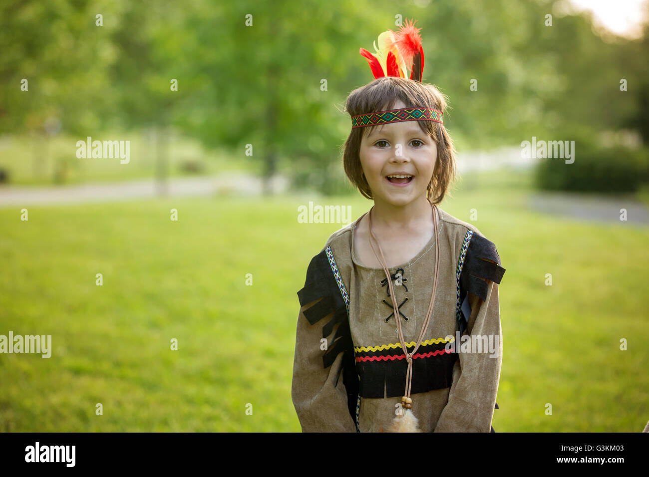 Cute portrait of native american boy with costumes, playing outdoor in ...