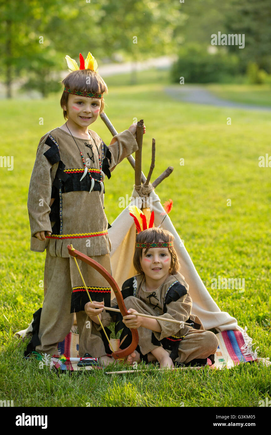 Cute portrait of native american boys with costumes, playing outdoor in ...