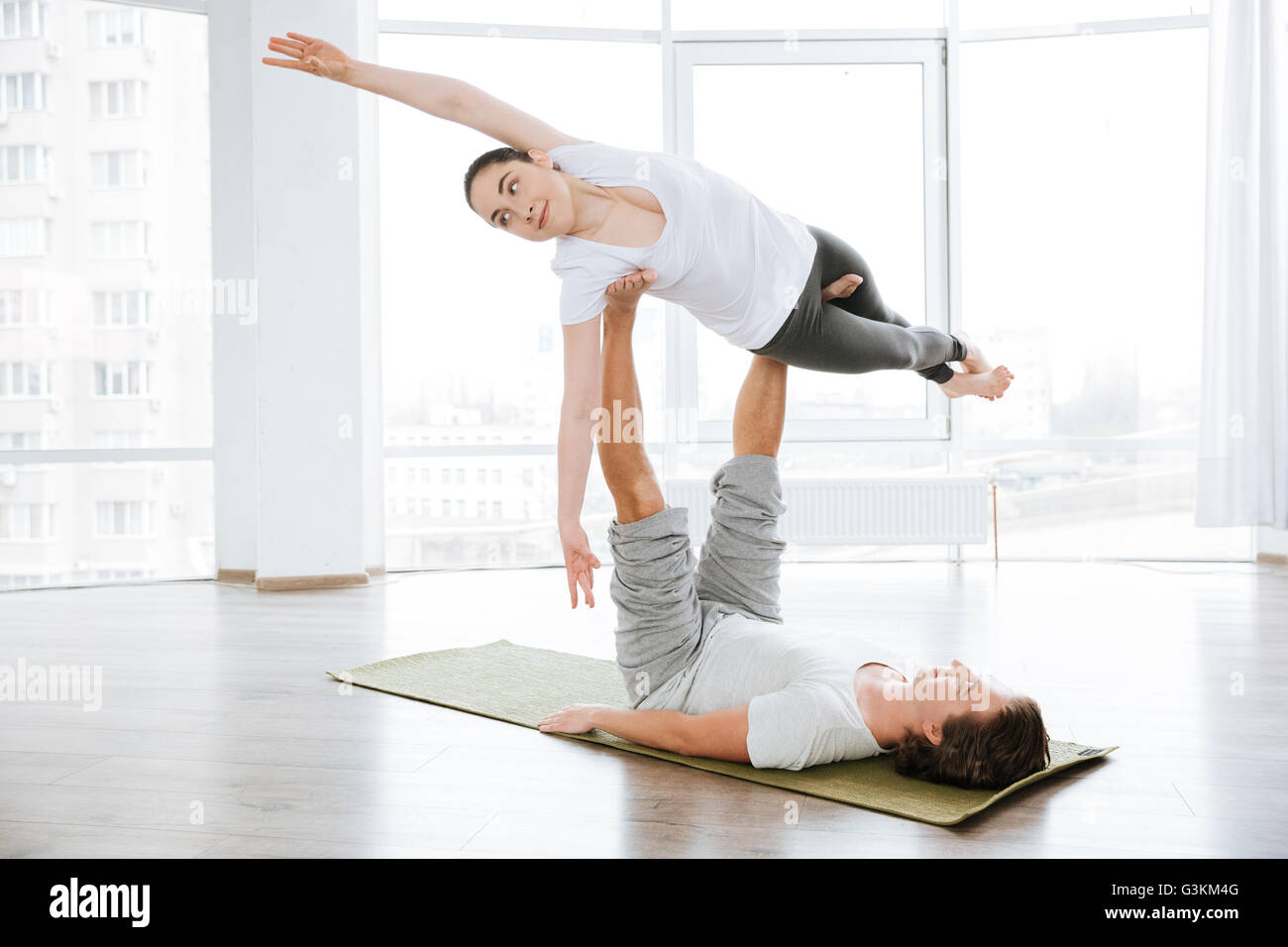 Beautiful woman balancing doing acro yoga with partner in studio Stock ...