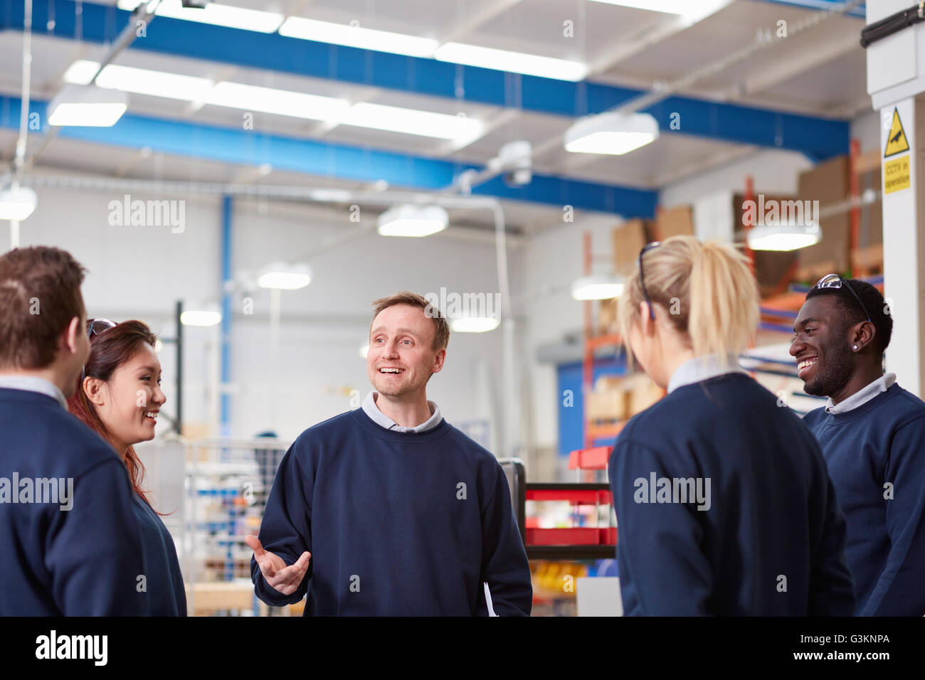 Manager explaining to team in manufacturing factory Stock Photo - Alamy