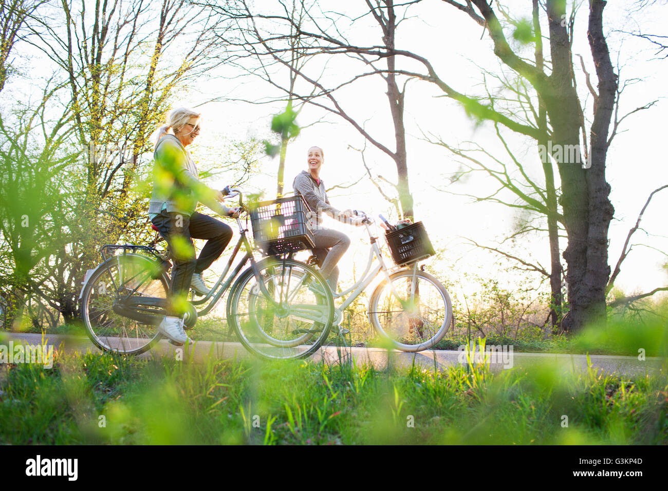 Side view of women cycling on bicycles Stock Photo - Alamy