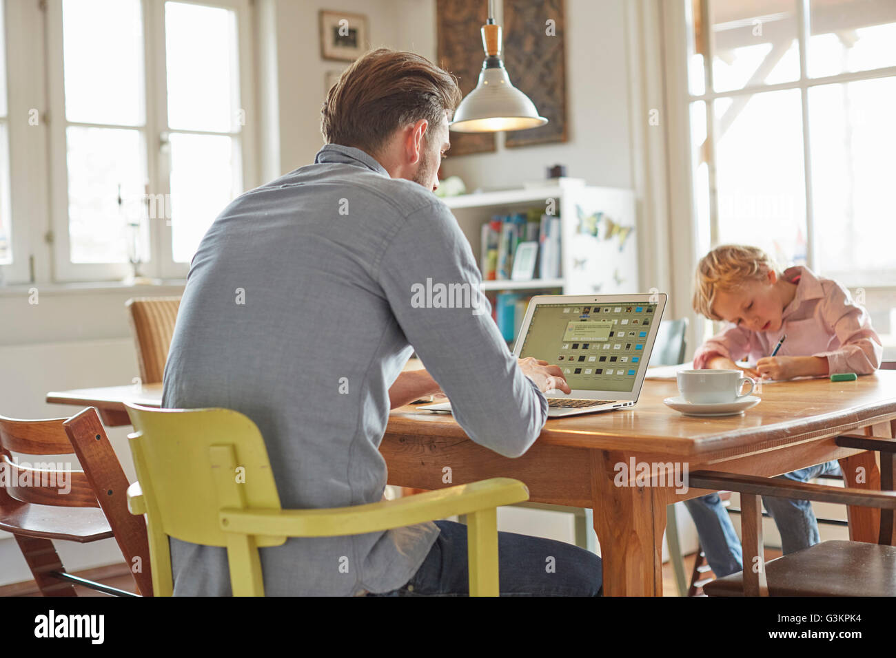 Father and son working in home office Stock Photo - Alamy