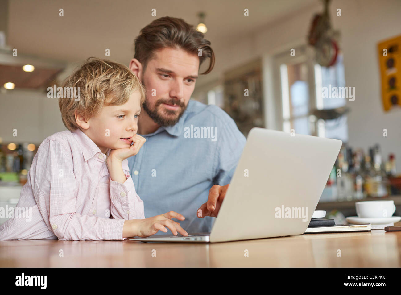 Father and son using laptop in home office Stock Photo - Alamy