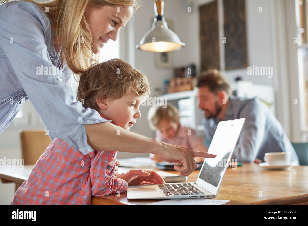 Parents and sons working in home office Stock Photo - Alamy