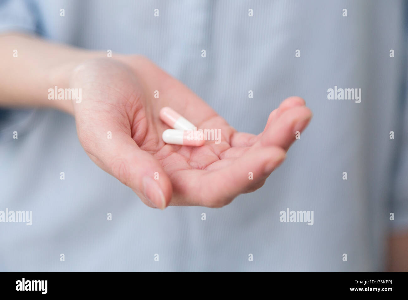 Womans hand holding capsules Stock Photo - Alamy